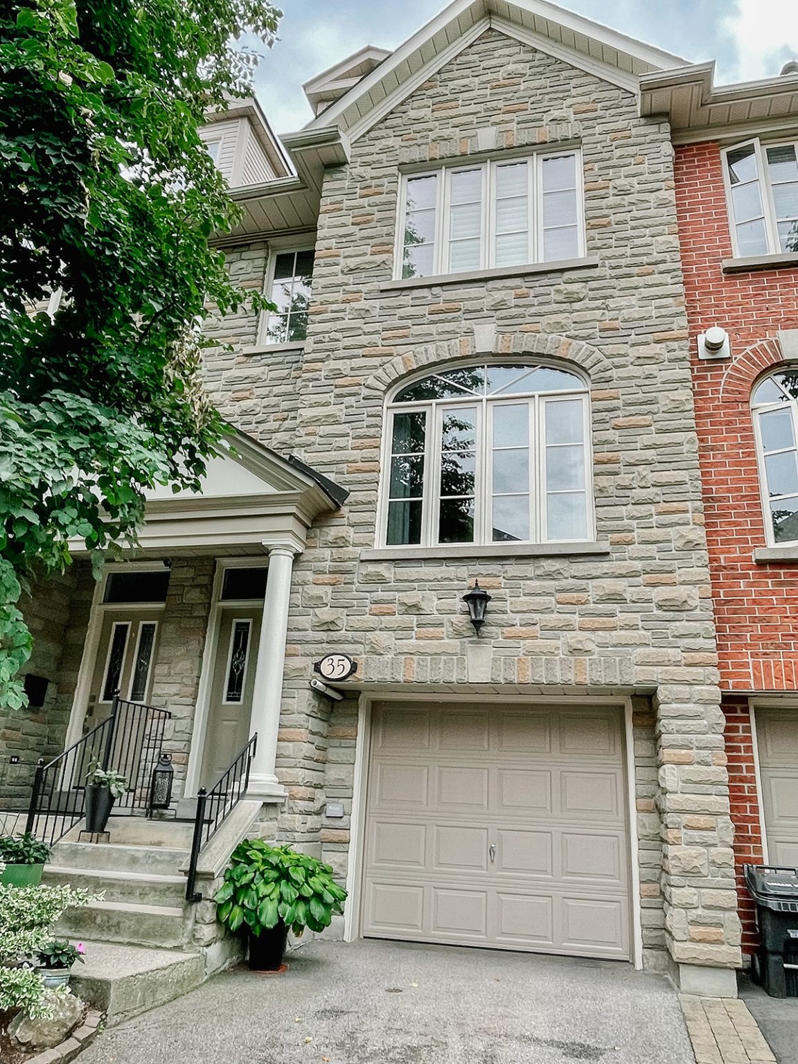 Elegant Casement Windows with Elliptical Transom – Stone Façade Home